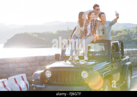 Chinese friends having fun in a jeep Stock Photo - Alamy