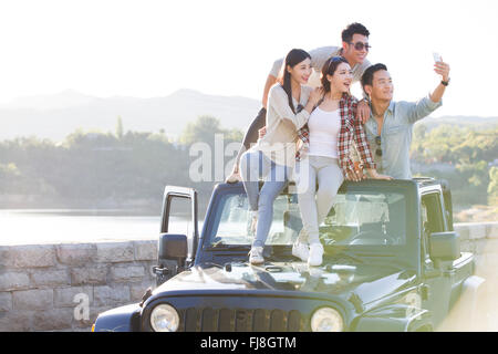 Chinese friends having fun in a jeep Stock Photo - Alamy
