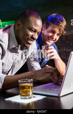 Two men having whiskey and using digital tablet at bar counter Stock ...