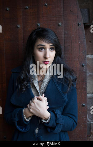 Worried woman at gate Stock Photo - Alamy