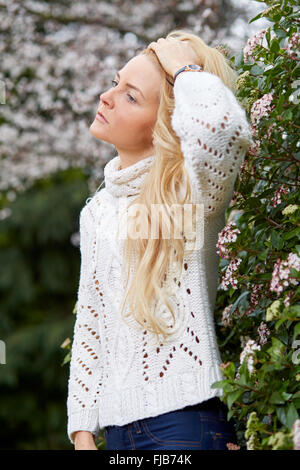 Sad woman looking down on blue background Stock Photo - Alamy