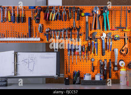 Garage tool rack with various tools and repair supplies on board and ...