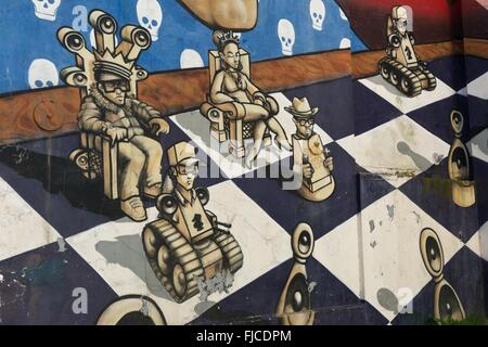 A graffiti of a chess game spray painted on a wall of a brick house ...