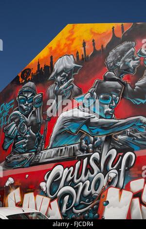 A graffiti of a DJ playing music spray painted on a pink wall Stock ...