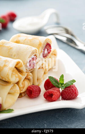Thin pancakes or crepes stuffed with cottage cheese on grey background ...