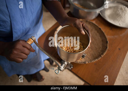 A woman grinding nuts, Africa Stock Photo - Alamy
