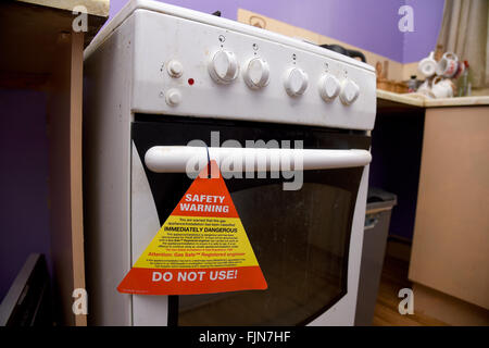Unsafe gas cooker with safety warning notice, UK Stock Photo - Alamy