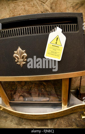Unsafe gas fire, fireplace with warning sign, UK Stock Photo - Alamy