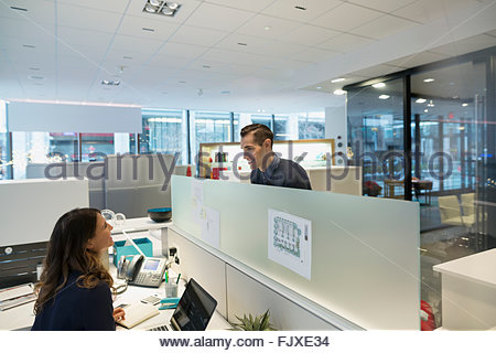 Business people talking over cubicle wall Stock Photo - Alamy