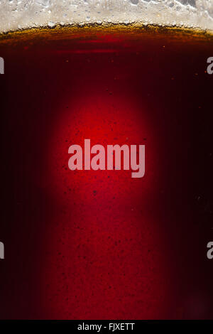 Red beer with bubbles foam in a glass, isolated on white background ...