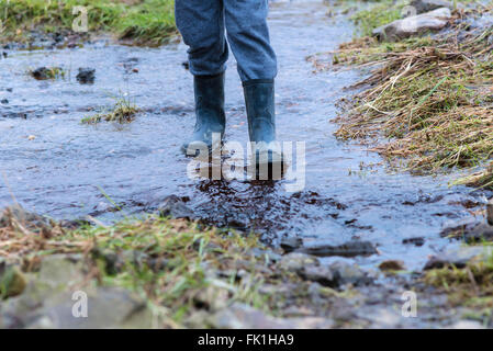 Child walking through stream with wellies on Stock Photo - Alamy