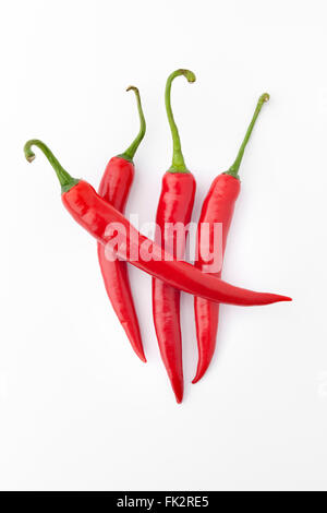 four spicy red peppers on a white background Stock Photo - Alamy