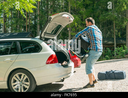 A man loading luggage into the boot of a car Stock Photo - Alamy