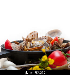 fresh clams stewed on an iron skillet over wite rustic wood table Stock ...