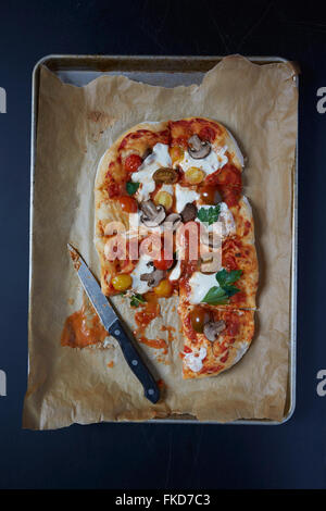 Homemade pizza on baking paper close up Stock Photo - Alamy