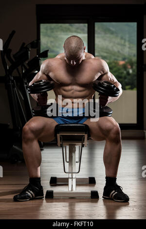 A muscular man in the gym, preparing for his workout, exudes ...