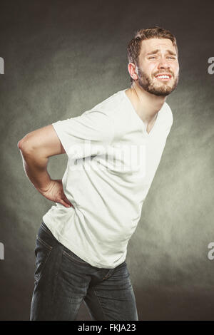Young man suffering from back pain on sofa at home Stock Photo - Alamy