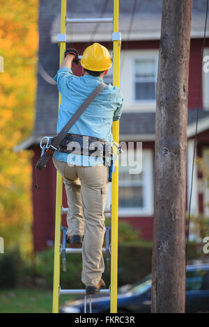 Cable lineman climbing a ladder to repair transmission line Stock Photo ...