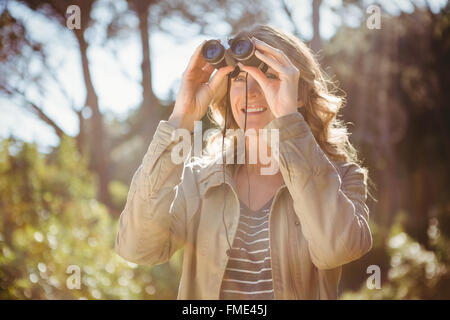 Woman using binoculars Stock Photo - Alamy