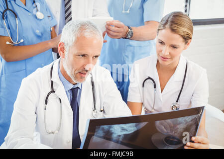 Two doctors examining x-ray report in medical office; panoramic banner ...