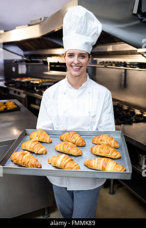 Happy baker holding tray of fresh bread Stock Photo - Alamy
