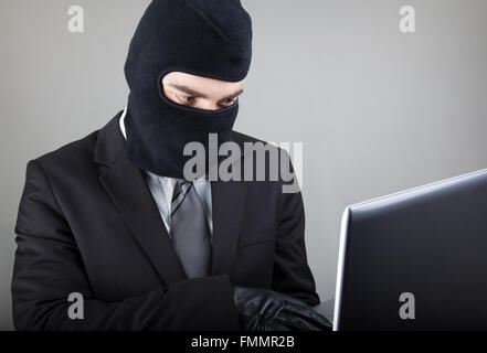 Computer Hacker in suit and tie stealing data from laptop computer ...