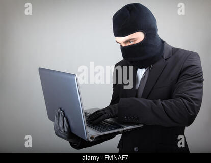 Computer Hacker in suit and tie stealing data from laptop computer ...