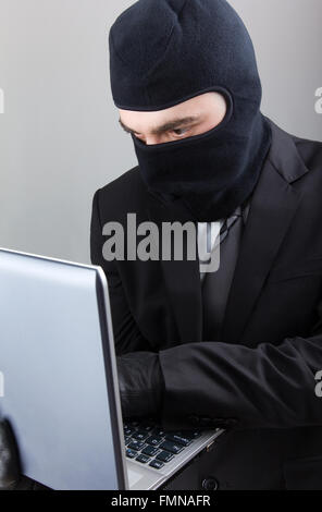 Computer Hacker in suit and tie stealing data from laptop computer ...