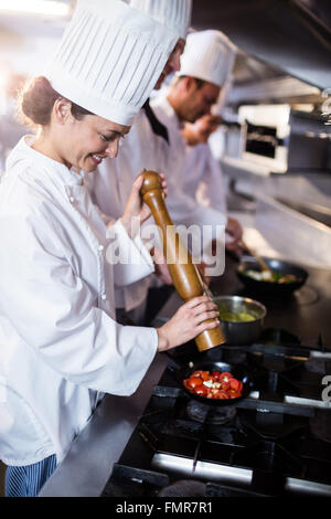 Chef sprinkling pepper on tomatos Stock Photo - Alamy