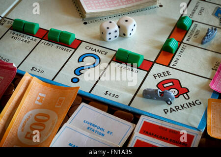 Monopoly board game with money, notes, counters and dice in studio ...