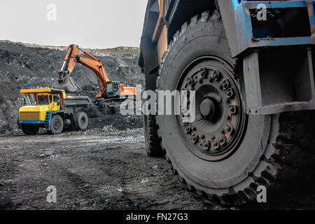 Excavator loading dump truck at coal mining Stock Photo - Alamy