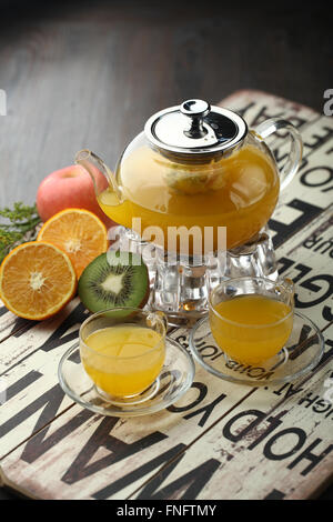 Glass cup of fruit tea with kiwi, lemon, mint and ginger on white ...