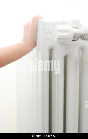 A human hand adjusting the temperature of a radiator Stock Photo - Alamy