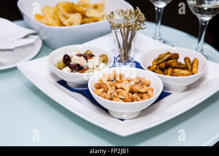 A table of nibbles, canapes etc. including nuts, crisps and olives at a ...
