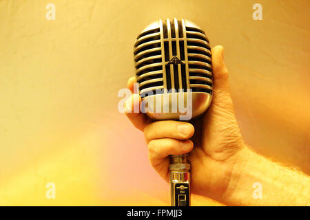 Vintage Microphone being held by a man Stock Photo - Alamy