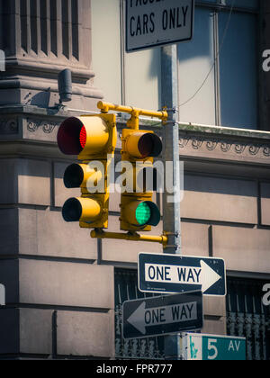 An urban city street with a green light for two traffic lights against ...