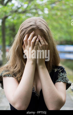 Woman hiding face in hands crying Stock Photo - Alamy