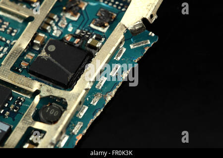 Close up burnt green microchip after short circuit due to water damage ...
