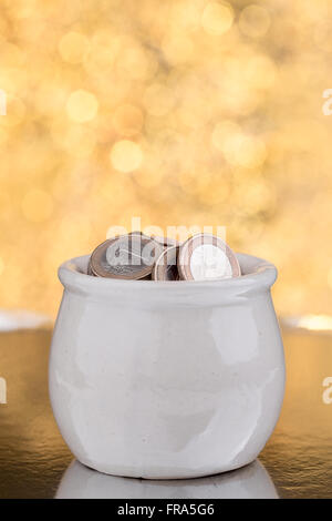 Golden pot full of Euro currency falling on pink background Stock Photo ...