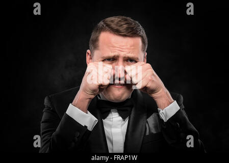 Crying man in formal suit touching head Stock Photo - Alamy