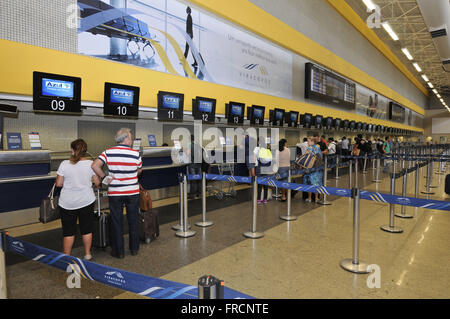 Passengers at Airport Check-in Counter: Side View of Woman Putting ...