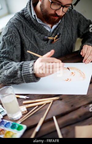 Young artist man drawing at art studio serious face thinking about ...