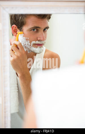 Young man shaving Stock Photo - Alamy