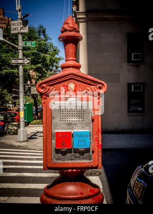 An emergency police and fire call box in New York City. A red metal box ...