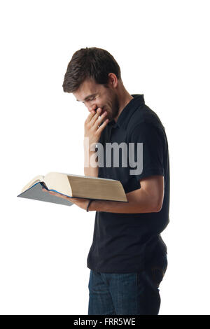 Man standing reading from a large book and smiling isolated on white ...