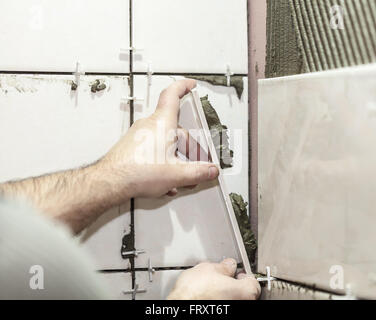 man puts the concrete tiles on the path Stock Photo - Alamy