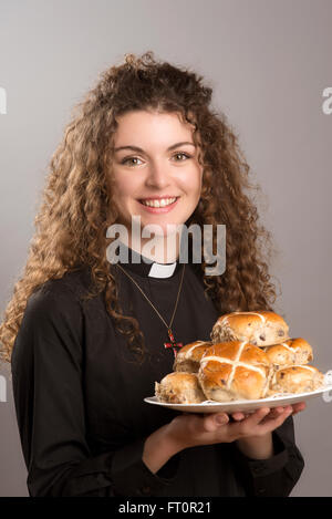 Young priest eating Hot Cross buns a tradition at Easter time Stock ...