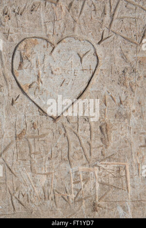 one old heart carved into stone wall in sun Stock Photo - Alamy