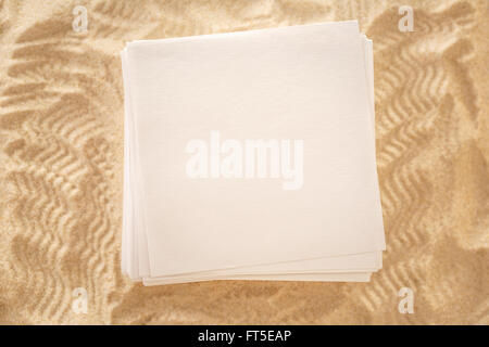 Blank sheets of paper on sand background Stock Photo - Alamy