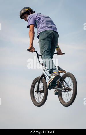 BMX bicycle rider flying and performing stunt No Hand in wooden quarter ...